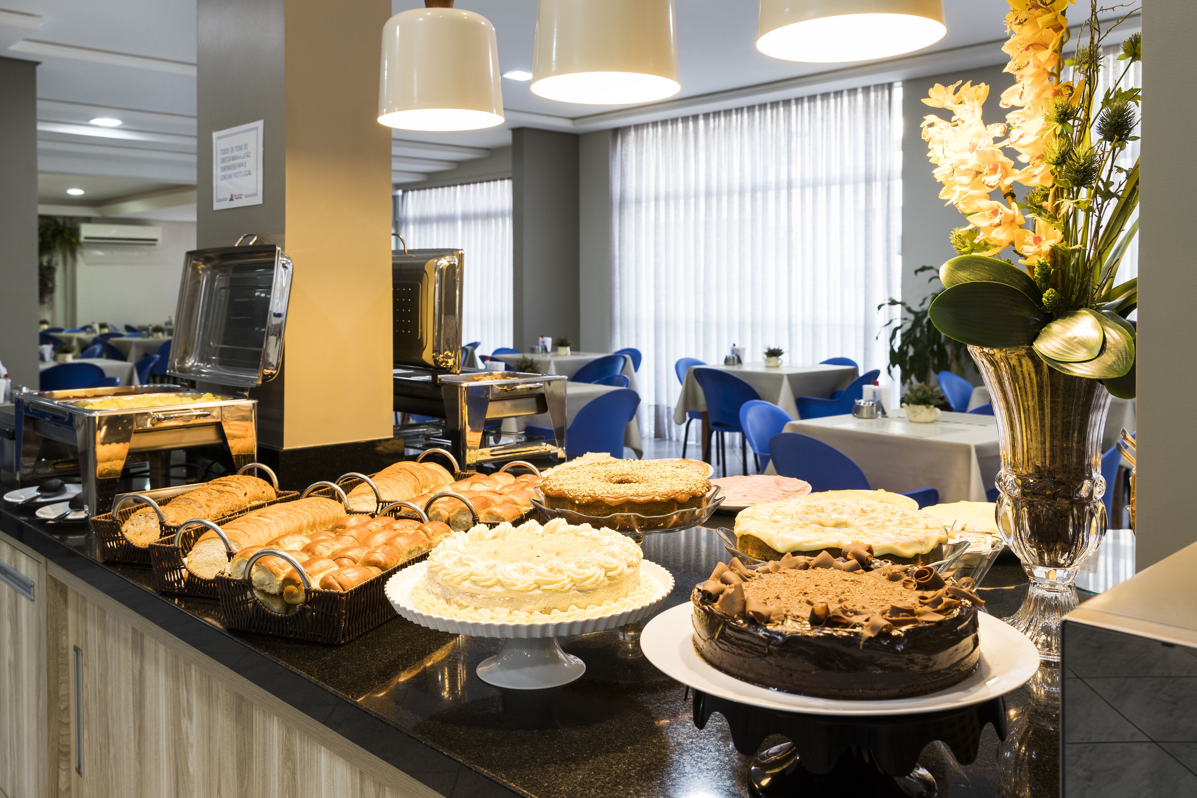 Um buffet com diversos pães e bolos.