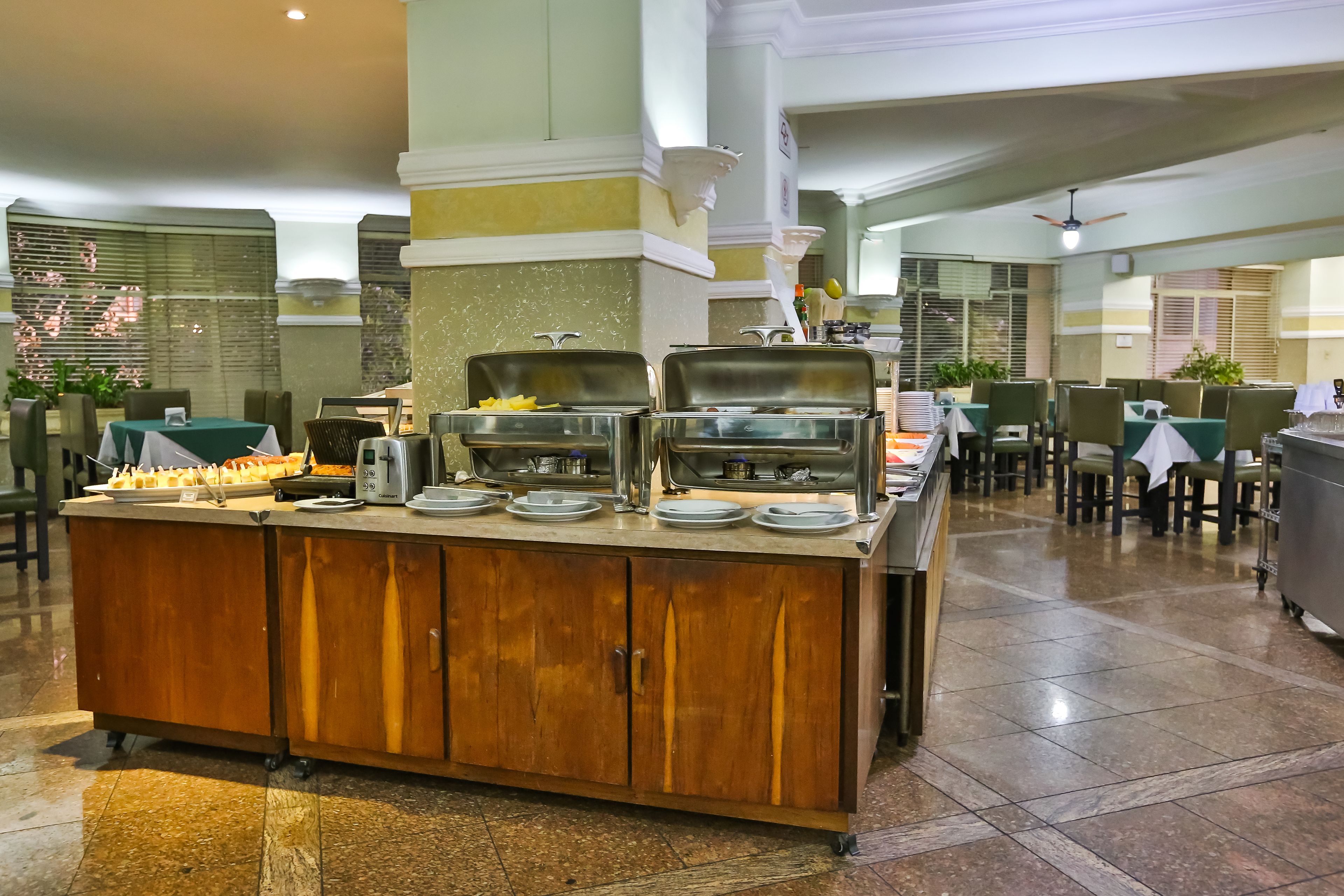 Uma mesa de buffet com várias estações de serviço, um balcão de madeira e uma variedade de alimentos.