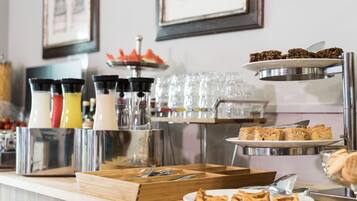 Disposição de buffet com diversos tipos de comida, dosadores de acompanhamentos e peças de vidro.