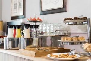 Disposição de buffet com diversos tipos de comida, dosadores de acompanhamentos e peças de vidro.