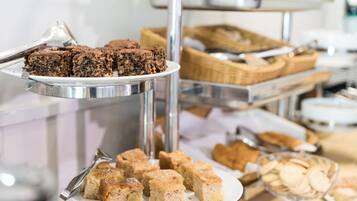 Buffet com diversos doces, incluindo brownies e bolo de maçã.