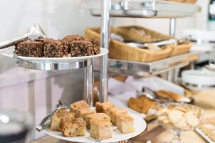 Buffet com diversos doces, incluindo brownies e bolo de maçã.