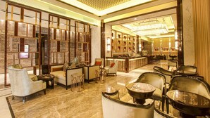 Um hall amplo com área de estar, balcão de recepção e bar.