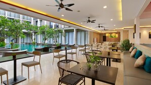 Amplo espaço interno com diversas opções de assentos, piscina e ventiladores de teto.