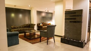Uma sala de estar moderna com sofá, poltrona e mesa de centro.