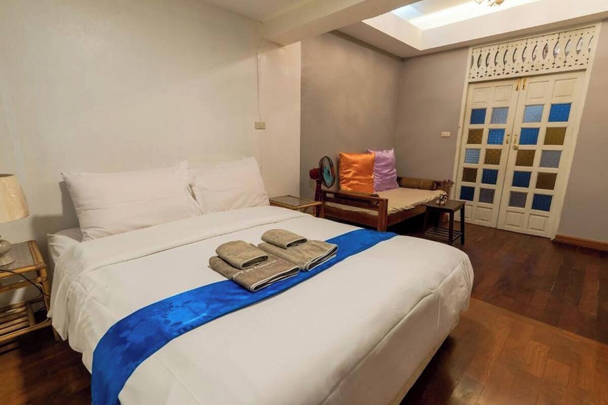 Quarto com uma cama grande, uma escrivaninha e um guarda-roupa.