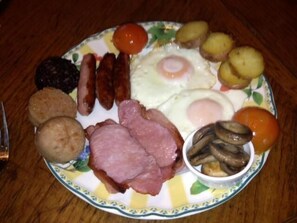 Um prato de comida de café da manhã com ovos, salsichas e batatas.