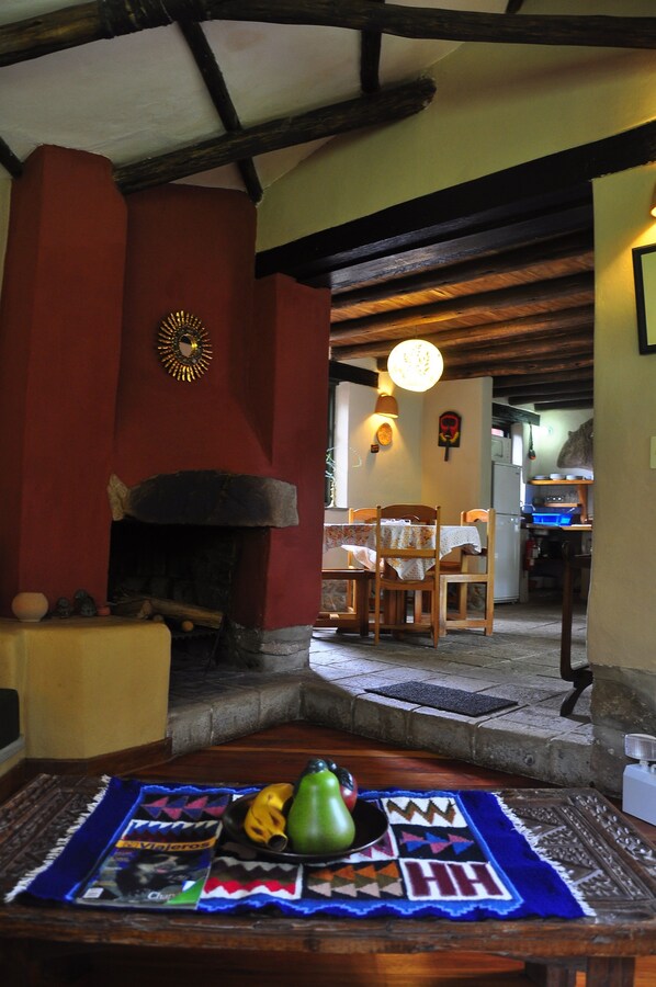 Um quarto acolhedor com lareira, móveis de madeira e uma mesa com jogo americano.