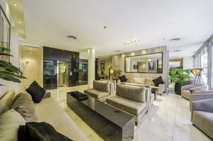 Uma sala de estar moderna com sofá, mesa de centro e um espelho grande.