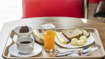Uma bandeja com itens de café da manhã, incluindo torradas, ovos, suco e café.