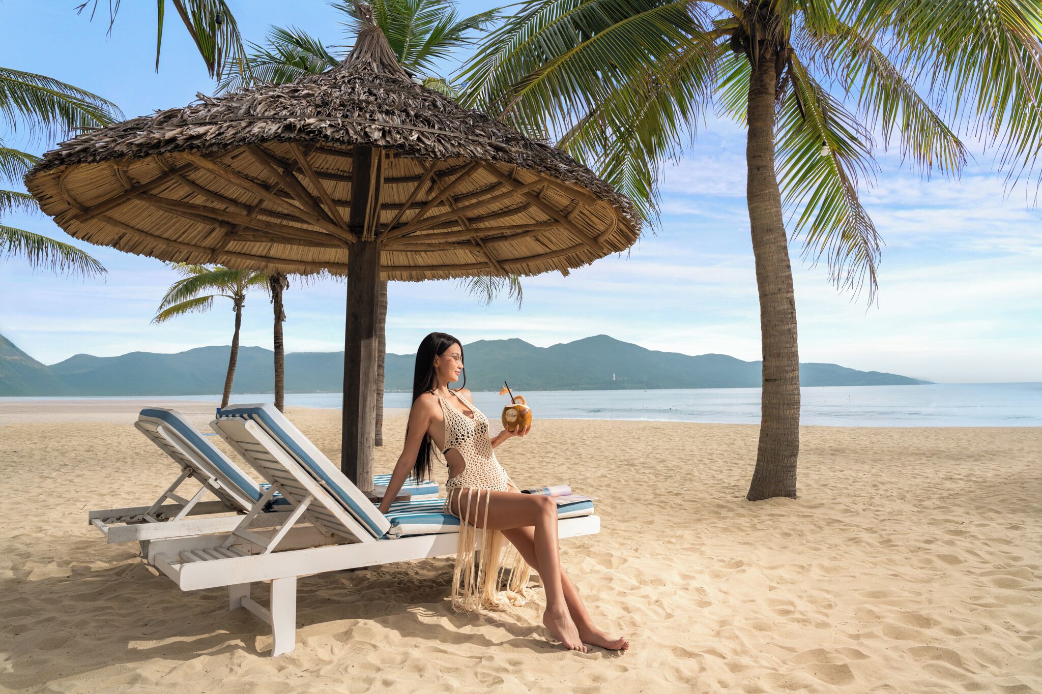 Na praia, praia de areia branca, espreguiçadeiras, guarda-sóis de praia 