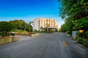 Um hotel Marigold com fachada moderna, hall amplo e vegetação exuberante ao redor da propriedade.