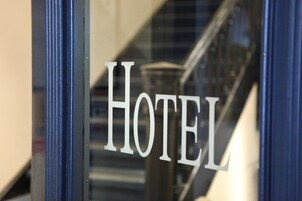 Placa de hotel com a palavra 'HOTEL' em letras grandes.