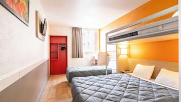 Quarto de hotel com duas camas, um guarda-roupa vermelho, uma escrivaninha e uma janela com cortinas.