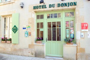 Um edifício com uma placa que diz "HOTEL DU DONJON".