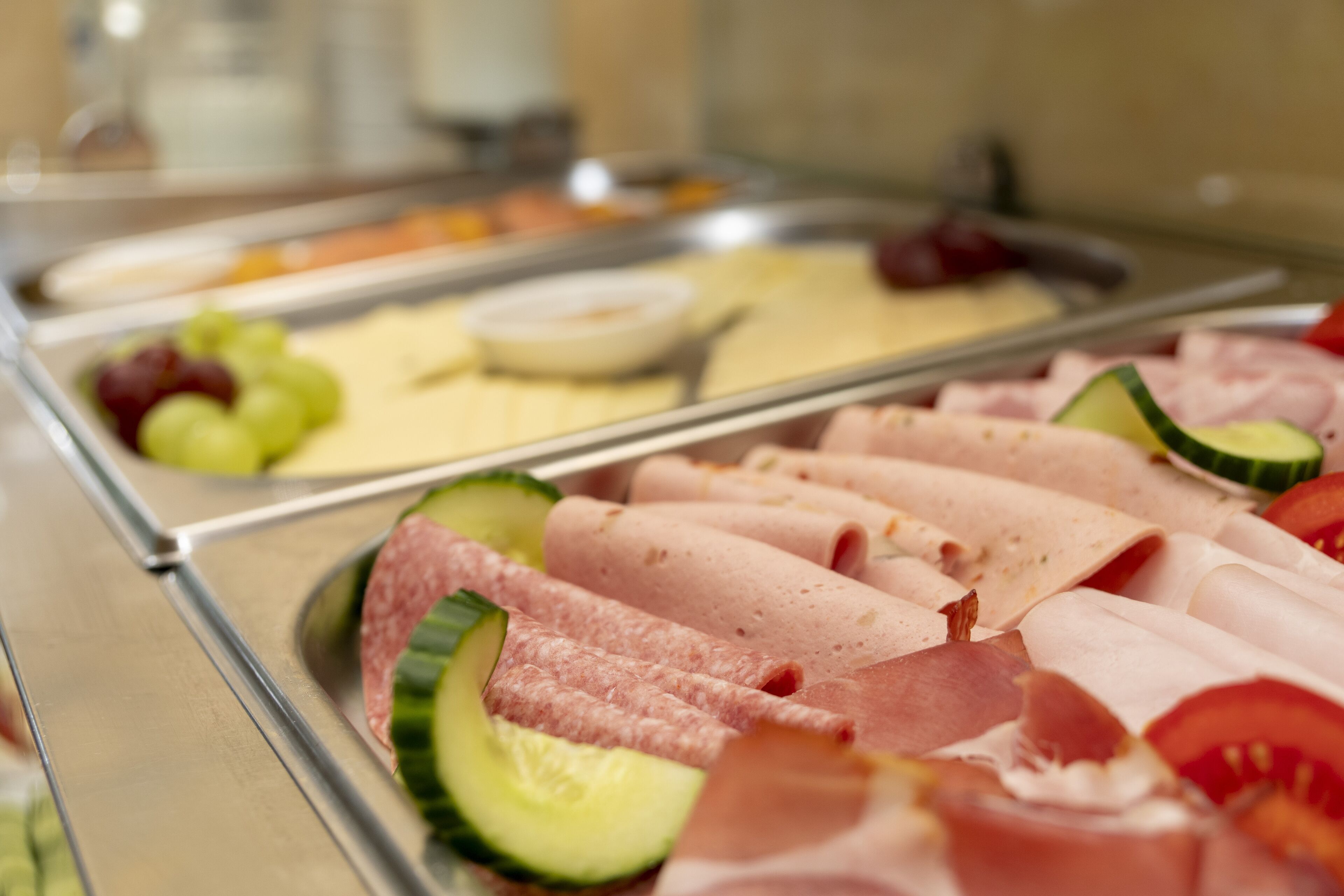 Buffet com diversos carnes, queijos e vegetais.
