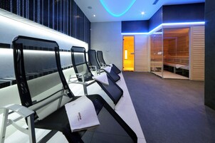 Uma área de spa moderna com cadeiras de massagem e sauna.