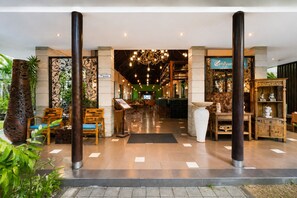 Um hall de hotel com balcão de recepção, área de estar e um candelabro.