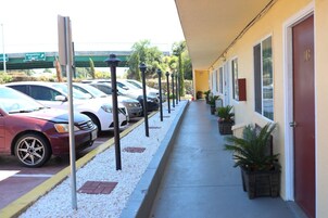 Corredor de hotel com carros estacionados e plantas em vasos ao longo da passarela.