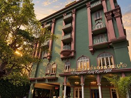 Um edifício histórico com várias sacadas e uma placa indicando que é o 'Hotel'.