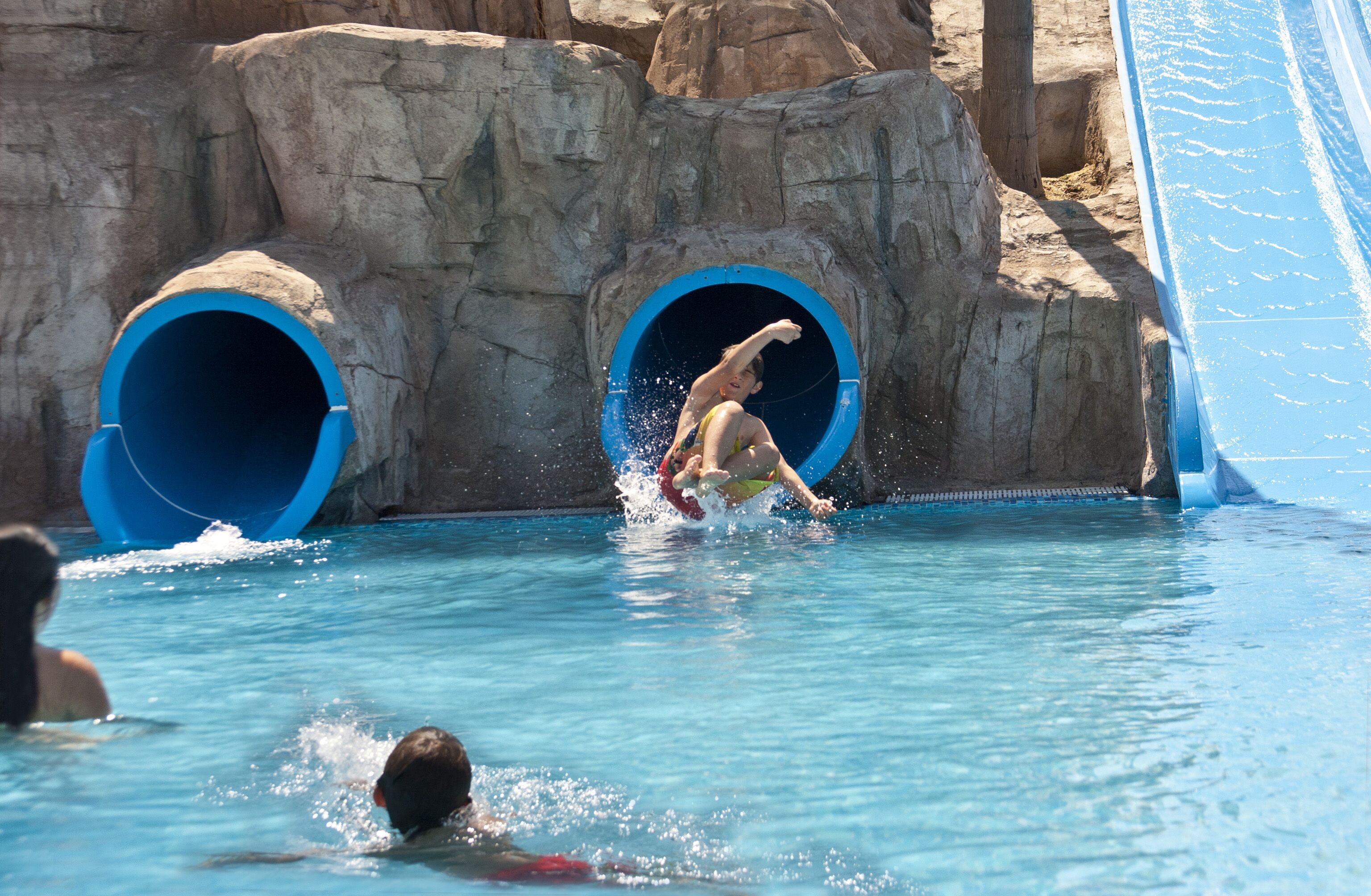 Uma piscina com duas aberturas circulares azuis na parede de rocha.