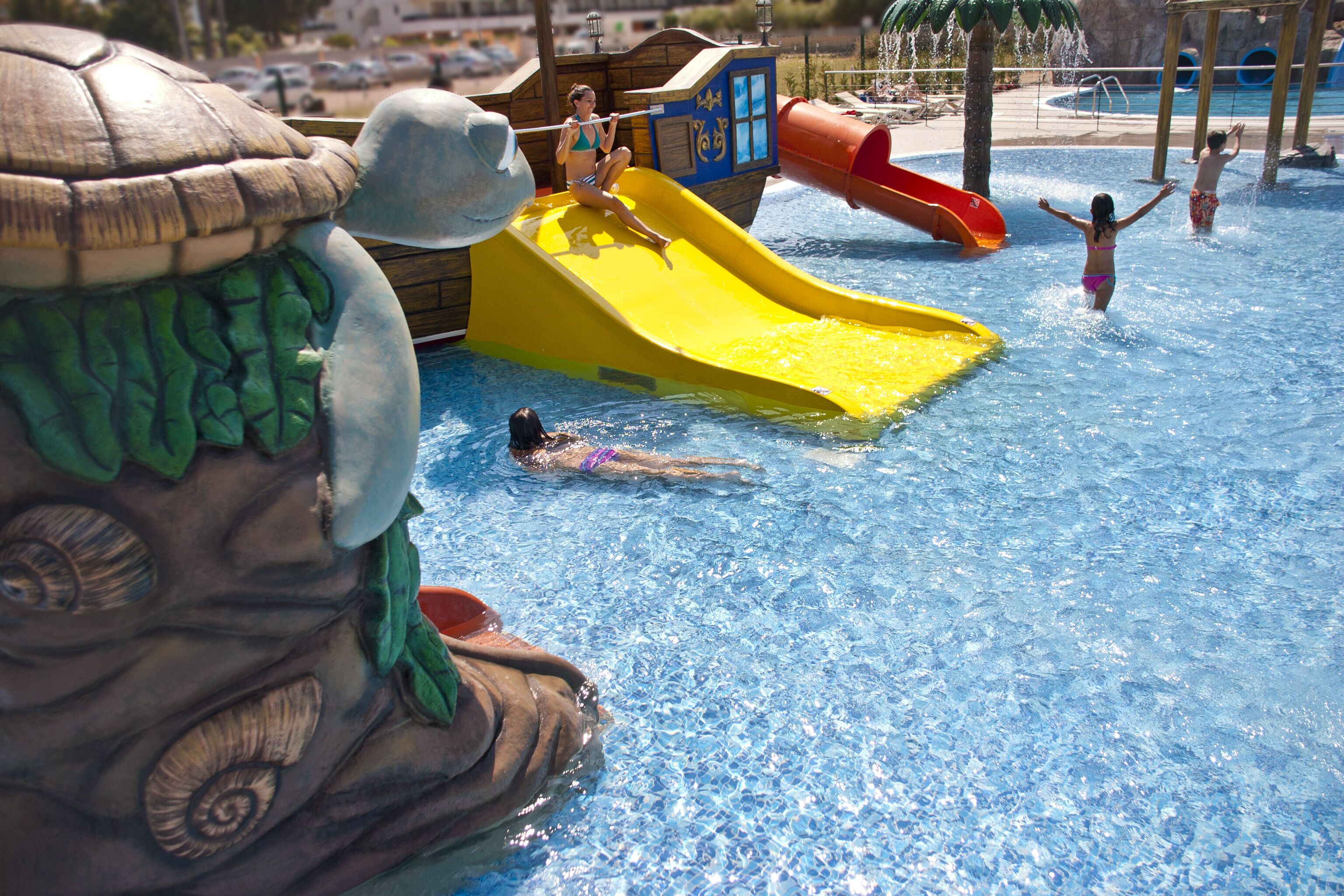Um parque aquático com escorregadores e uma grande escultura de tartaruga.