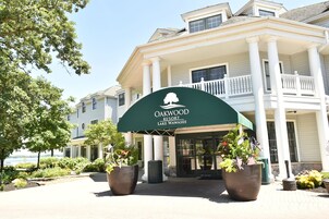 A entrada do Oakwood Resort, com varanda coberta, grandes vasos de plantas e vista para o Lago Wawasee.