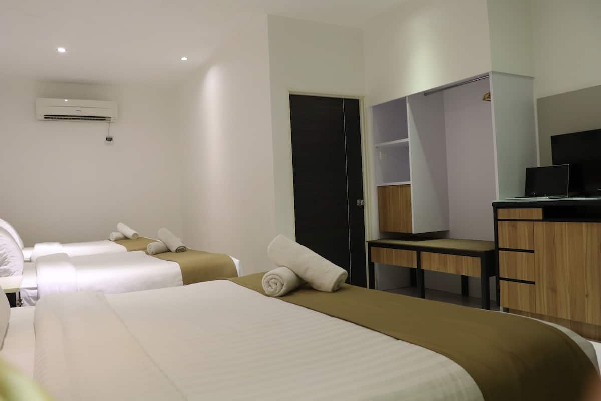Quarto de hotel com duas camas, uma escrivaninha, um guarda-roupa e uma televisão.