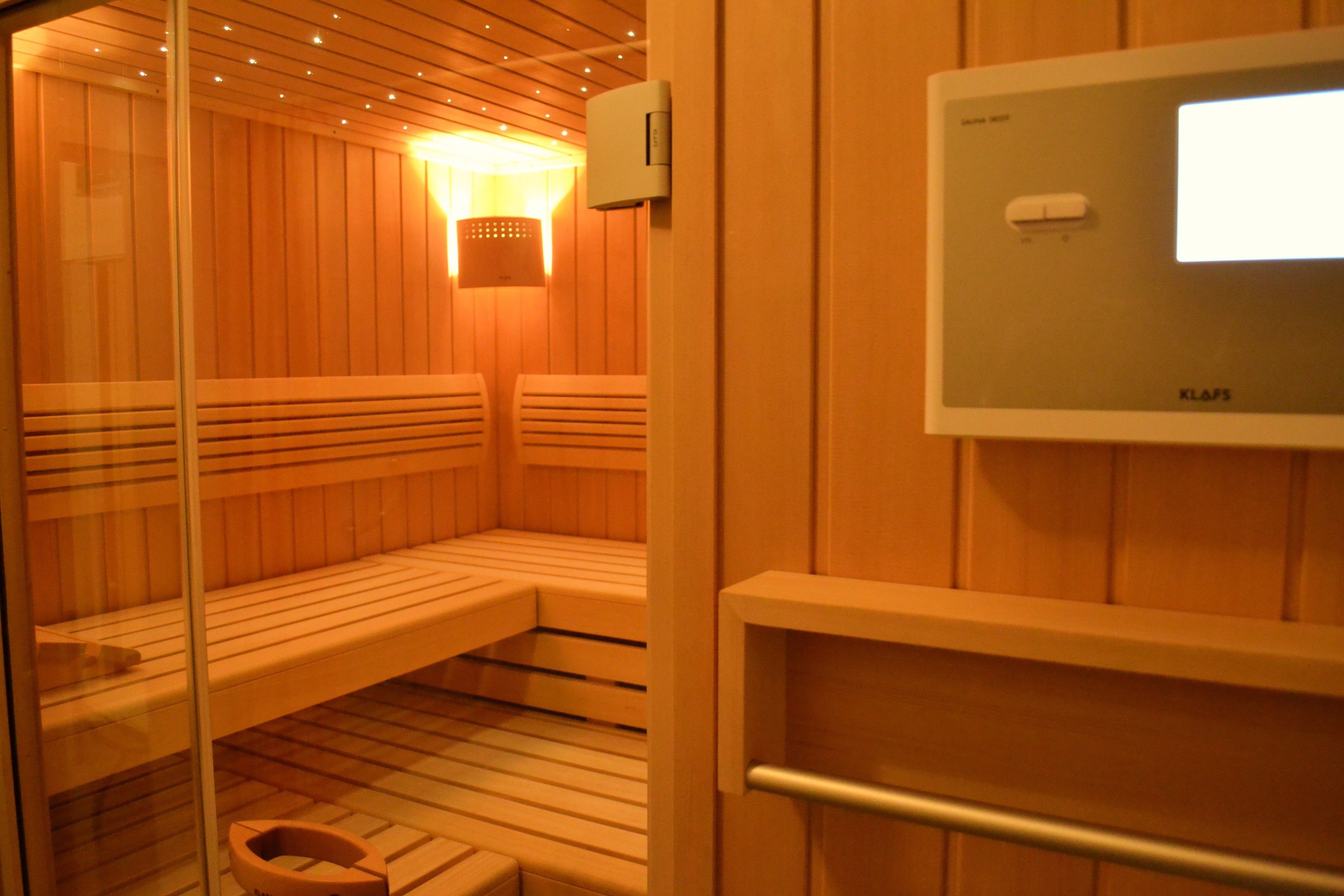 Uma sauna com bancos de madeira e painel de controle.