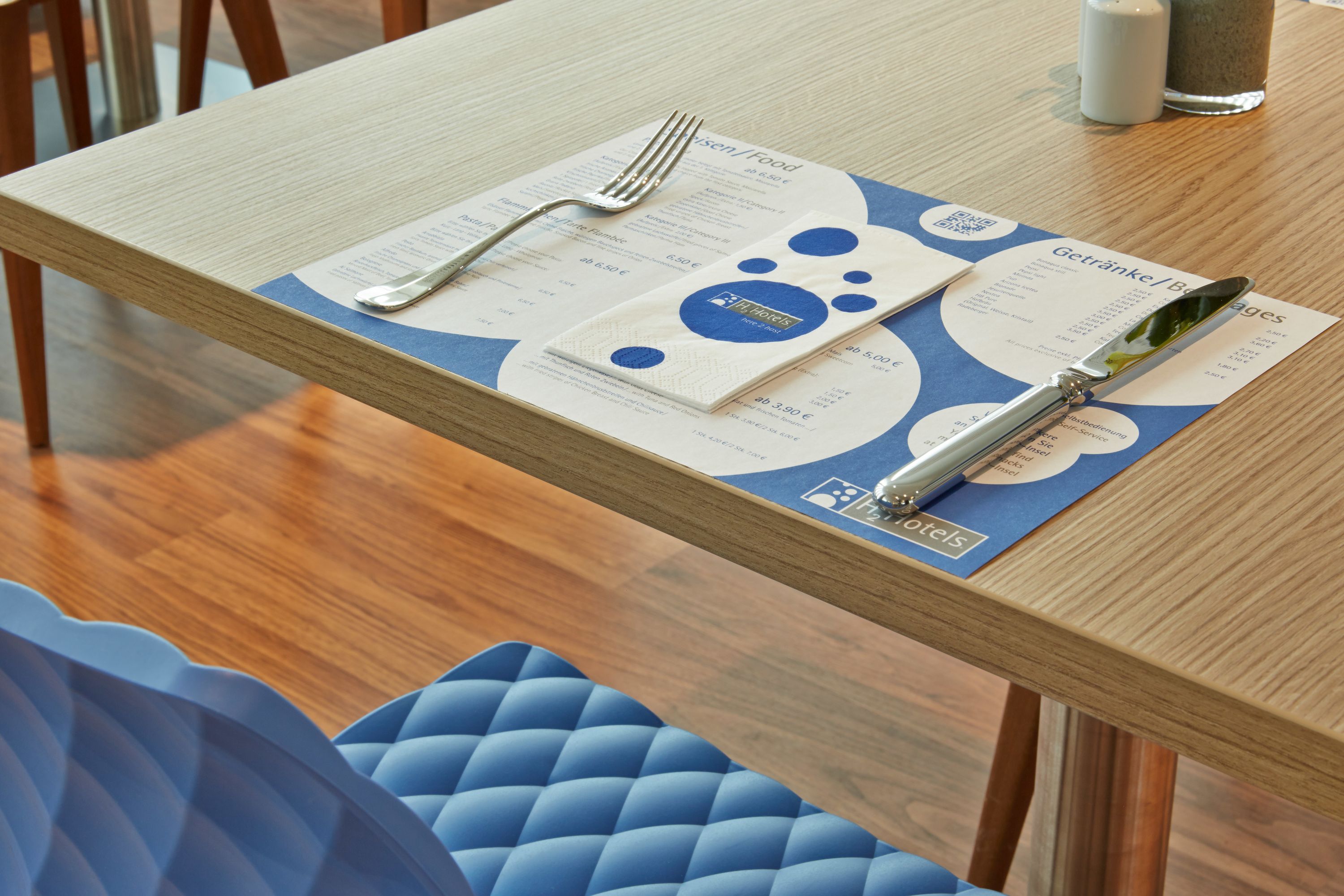 Uma mesa com um menu, um garfo e uma faca.