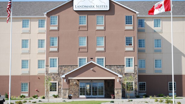 Um hotel com vários andares e uma placa de destaque com a inscrição "Landmark Suites".