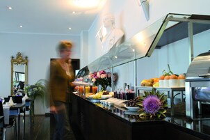Uma área de buffet com diversos tipos de comida e uma estátua decorativa.