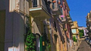 Vista da rua com um edifício ostentando uma placa com a inscrição 'il Piccolo Albergo'.