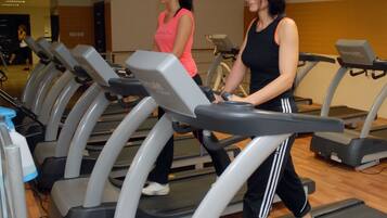 Uma academia com esteiras e equipamentos de exercícios.