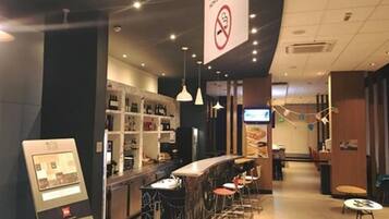 Uma área de bar moderna com balcão, banquetas e uma seleção de bebidas.
