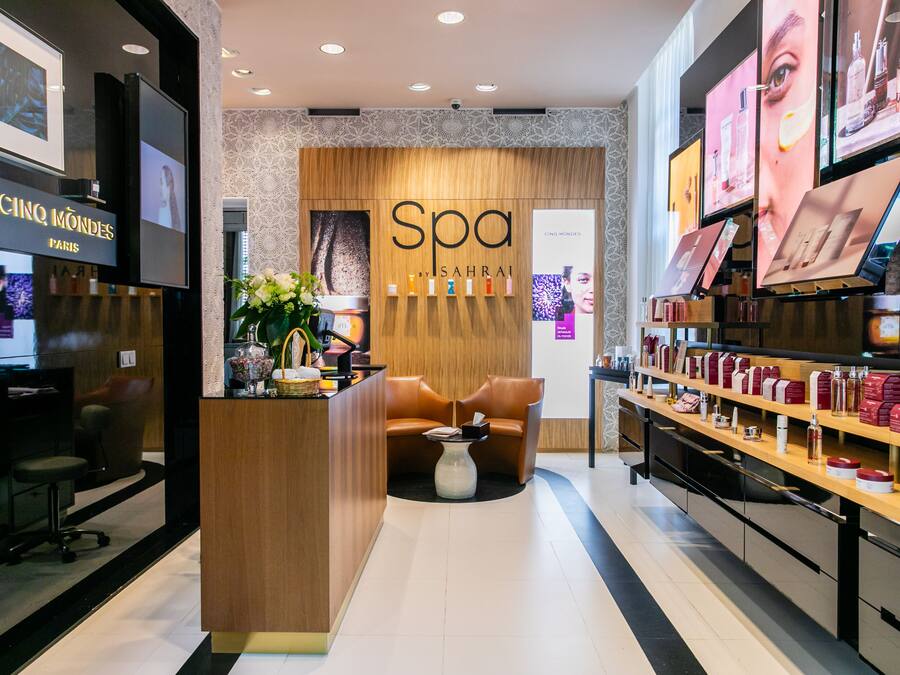 Um spa moderno com balcão de atendimento, assentos de couro e prateleiras com produtos de spa.