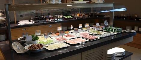 Um buffet com diversos pratos e acompanhamentos.