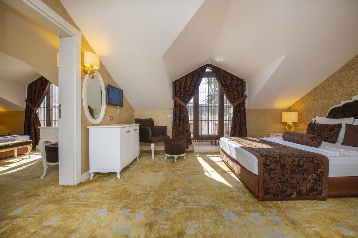 Quarto com uma cama grande, cômoda, cadeira e escrivaninha.