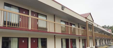 Um motel com vários quartos, cada um com porta e janela.