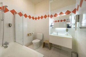 Casa de banho com chuveiro, sanita e lavatório.