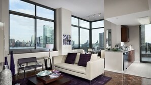 Uma sala de estar moderna com sofá, mesa de centro e vista para a cidade.