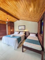 Quarto com duas camas, teto de madeira e uma moldura na parede.