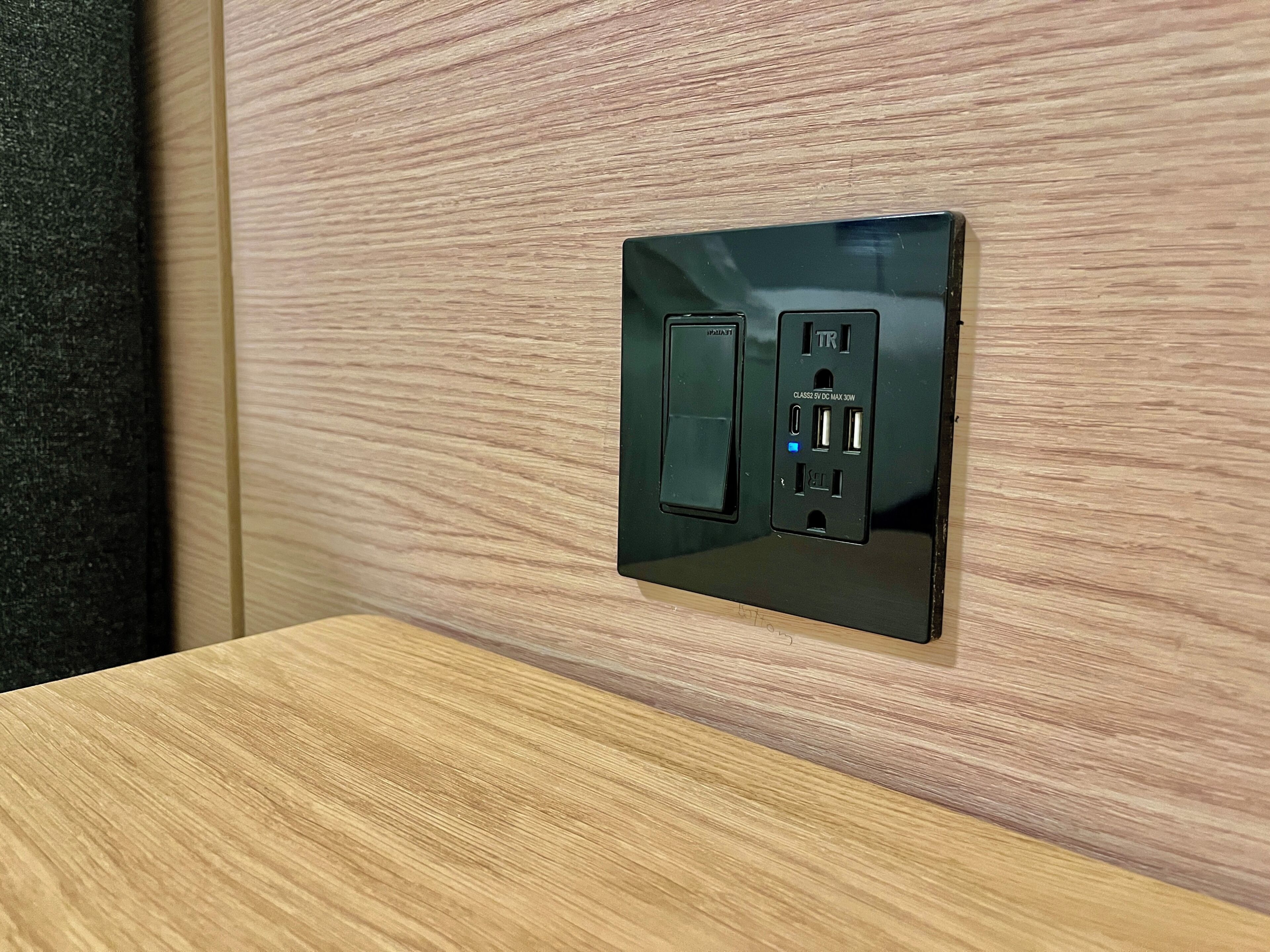 Tomada elétrica na parede com porta USB e entrada padrão.