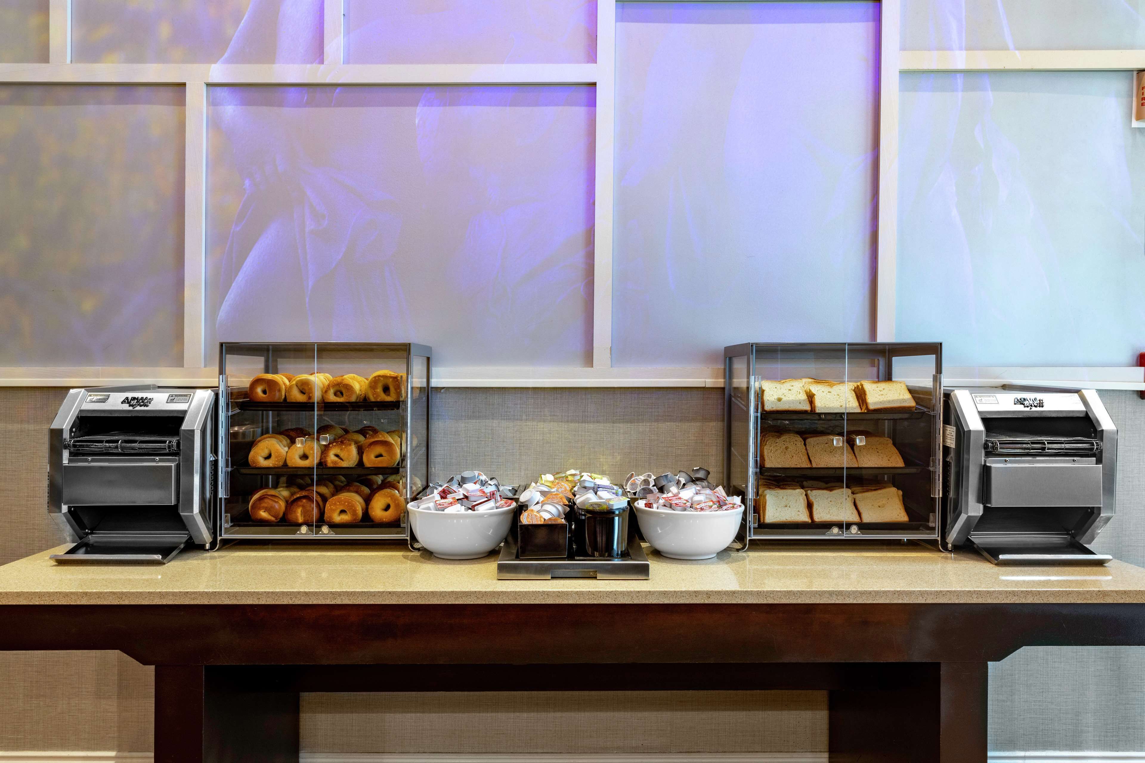 Um balcão de buffet com diversos alimentos e uma máquina de café.