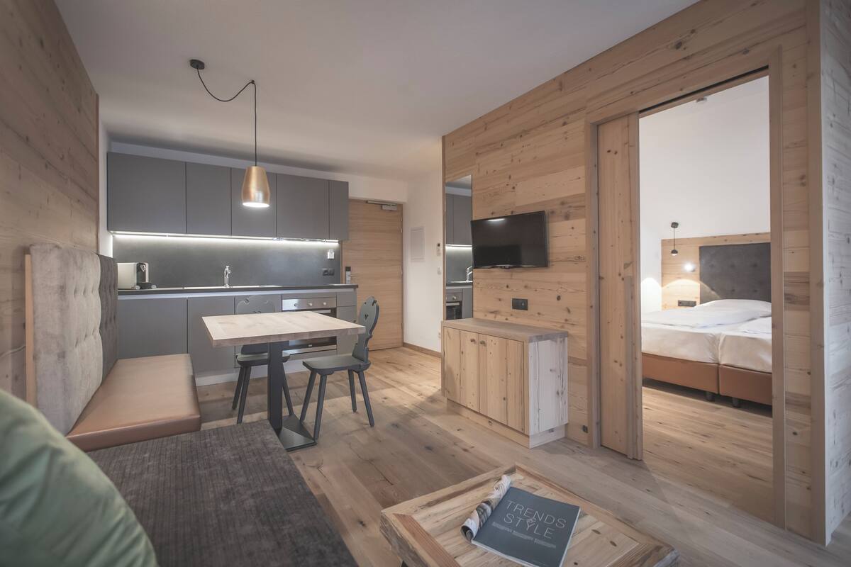 Um espaço compacto com cozinha compacta, área de refeições, cama e televisão.