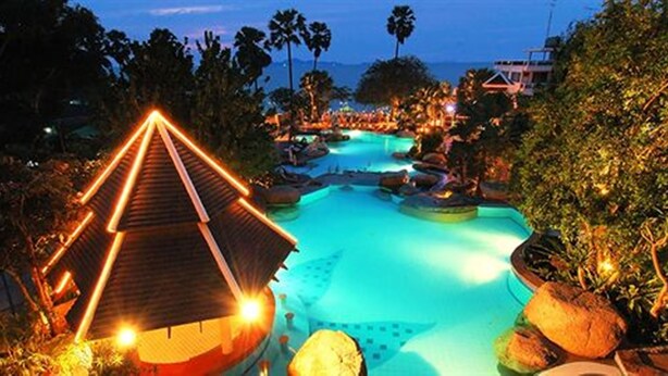 Área de piscina de resort com uma estrutura em formato de pirâmide e uma grande piscina.