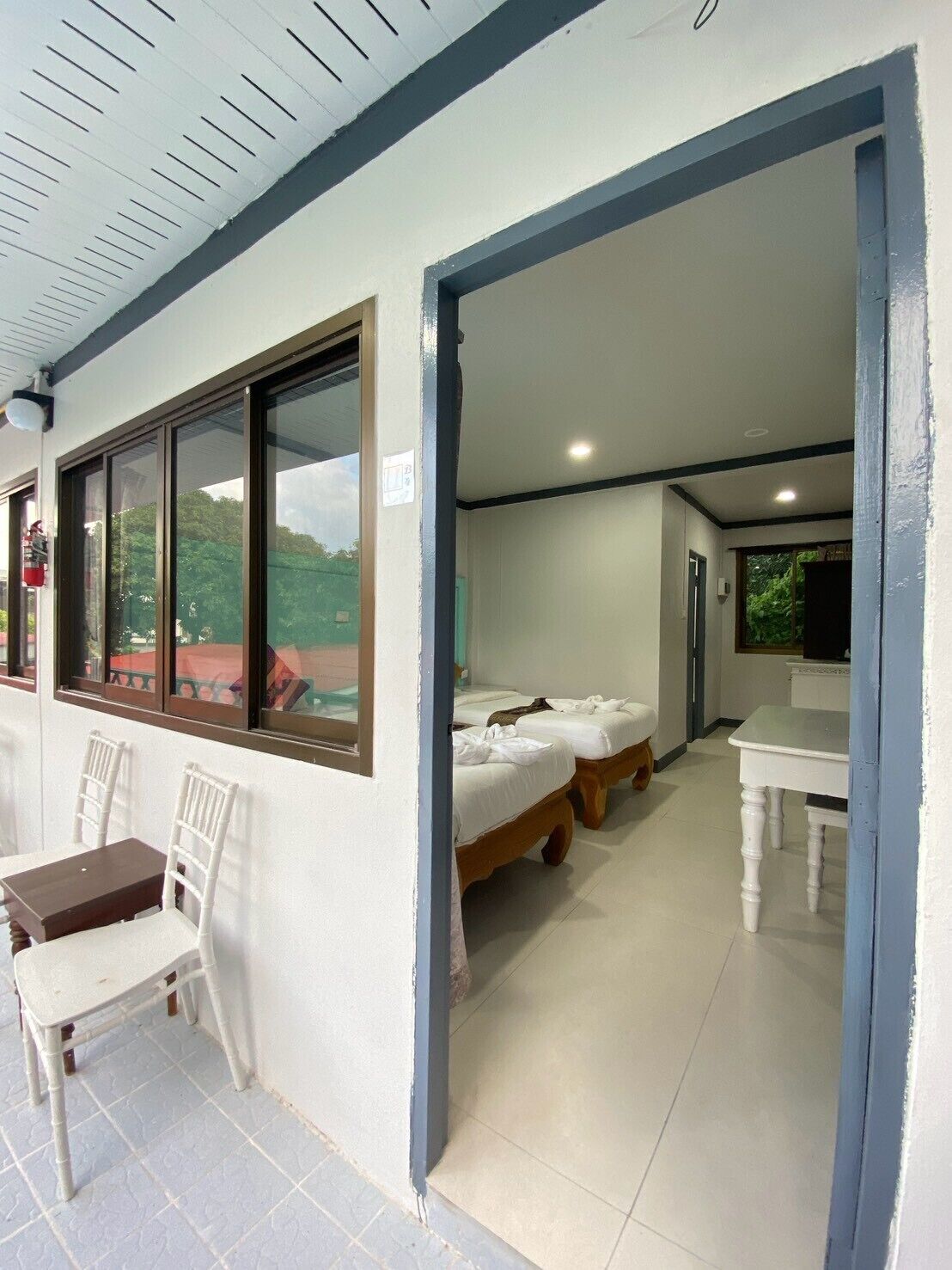Quarto com duas camas, uma mesa e uma cadeira.