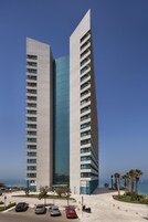 Um edifício alto e moderno com fachada de vidro e telhado plano.