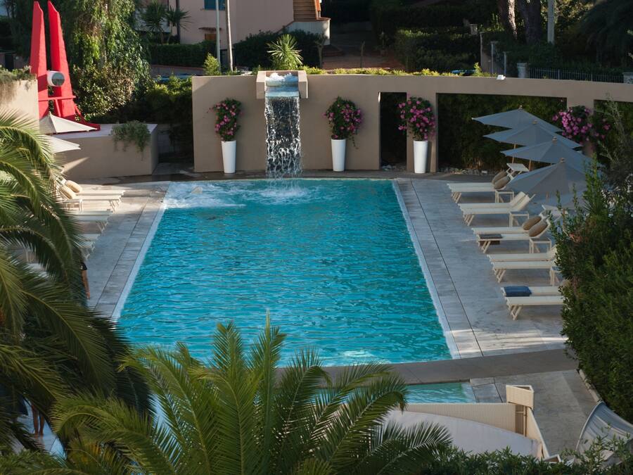 Piscina exterior sazonal, uma piscina com cascata, guarda-sóis