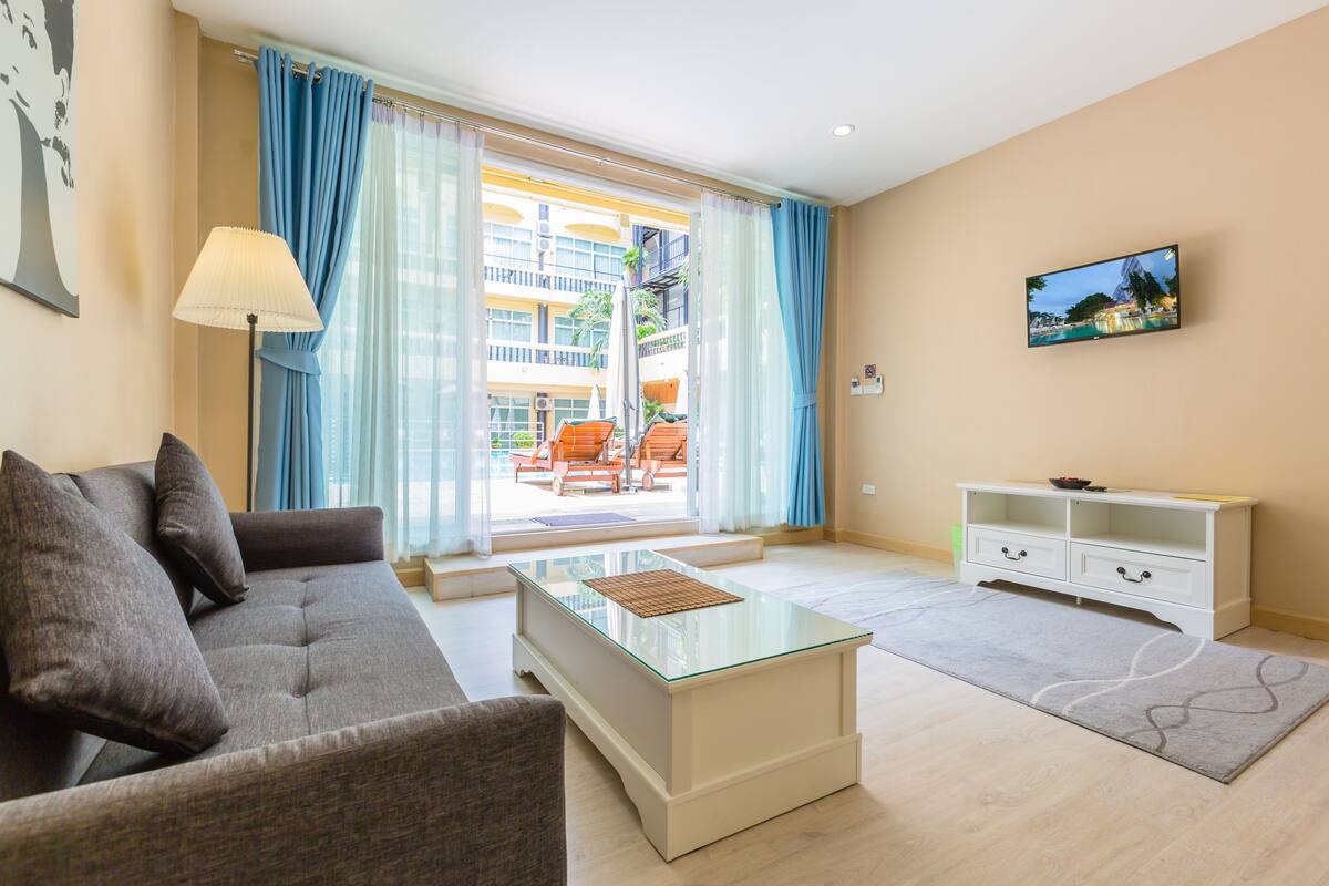 Uma sala de estar moderna com um sofá, mesa de centro e televisão.